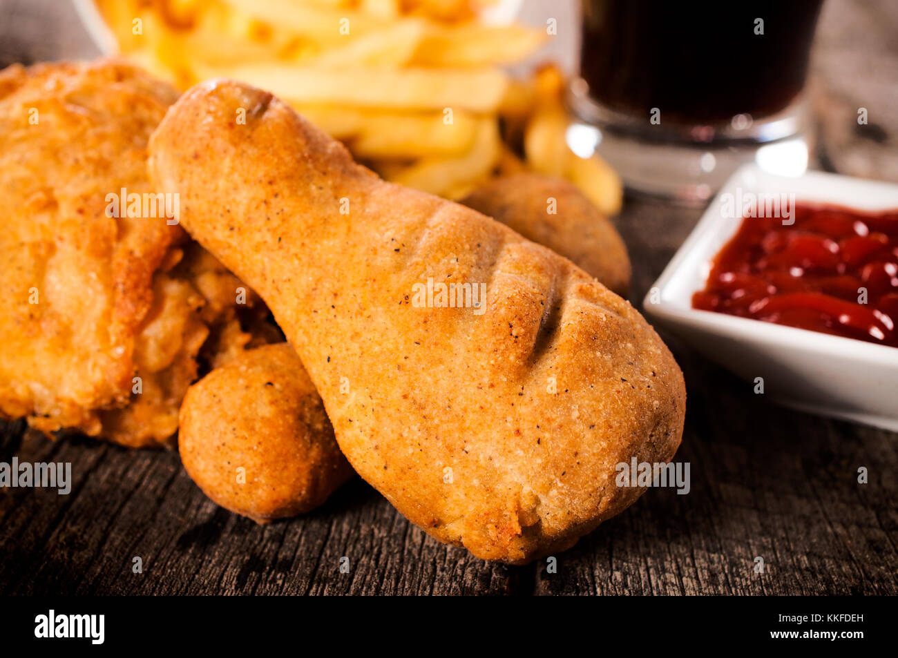 Fried chicken legs with french fries in the background.Selective focus ...