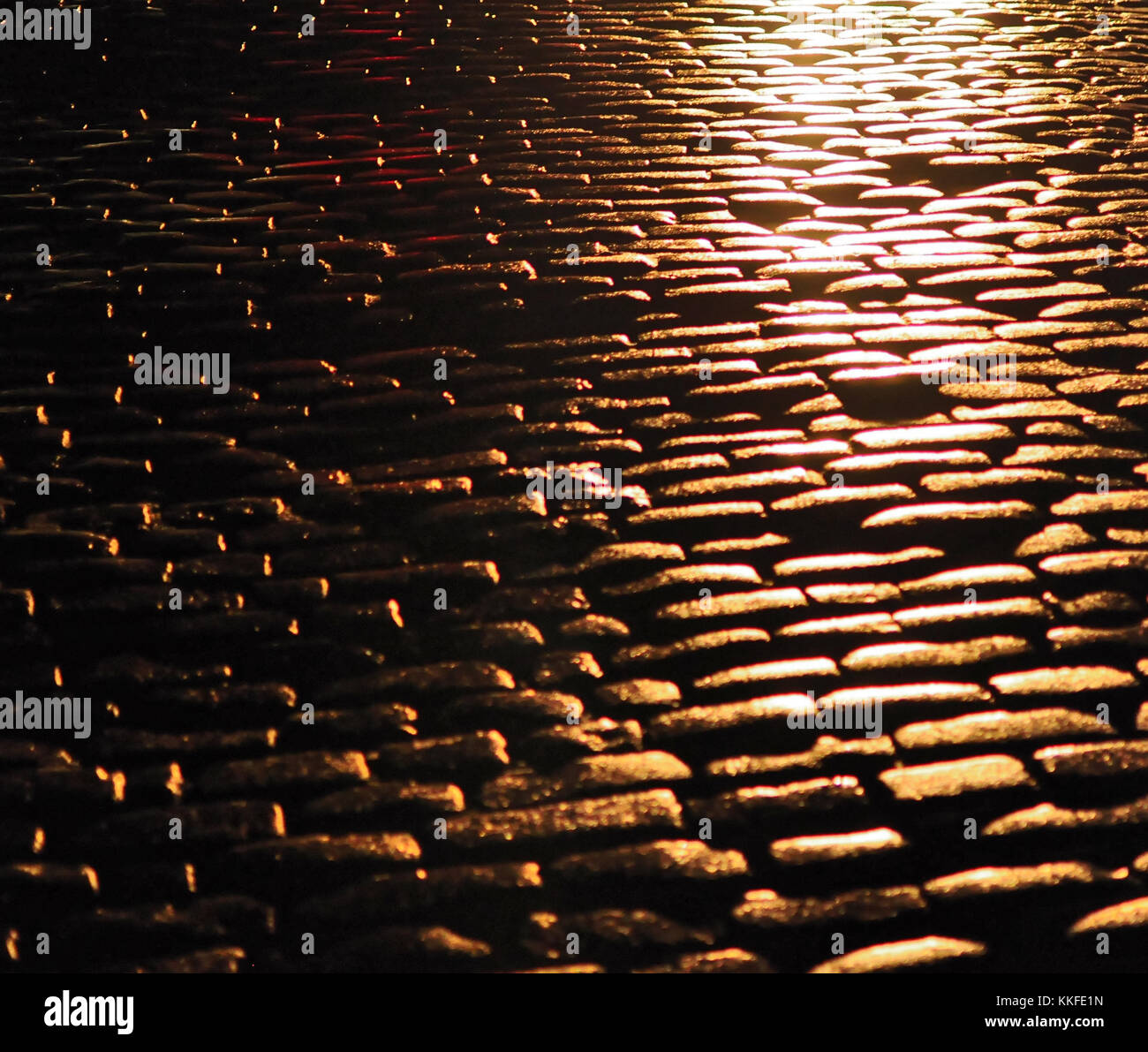 A wet cobbled street shining in sunlight Stock Photo - Alamy