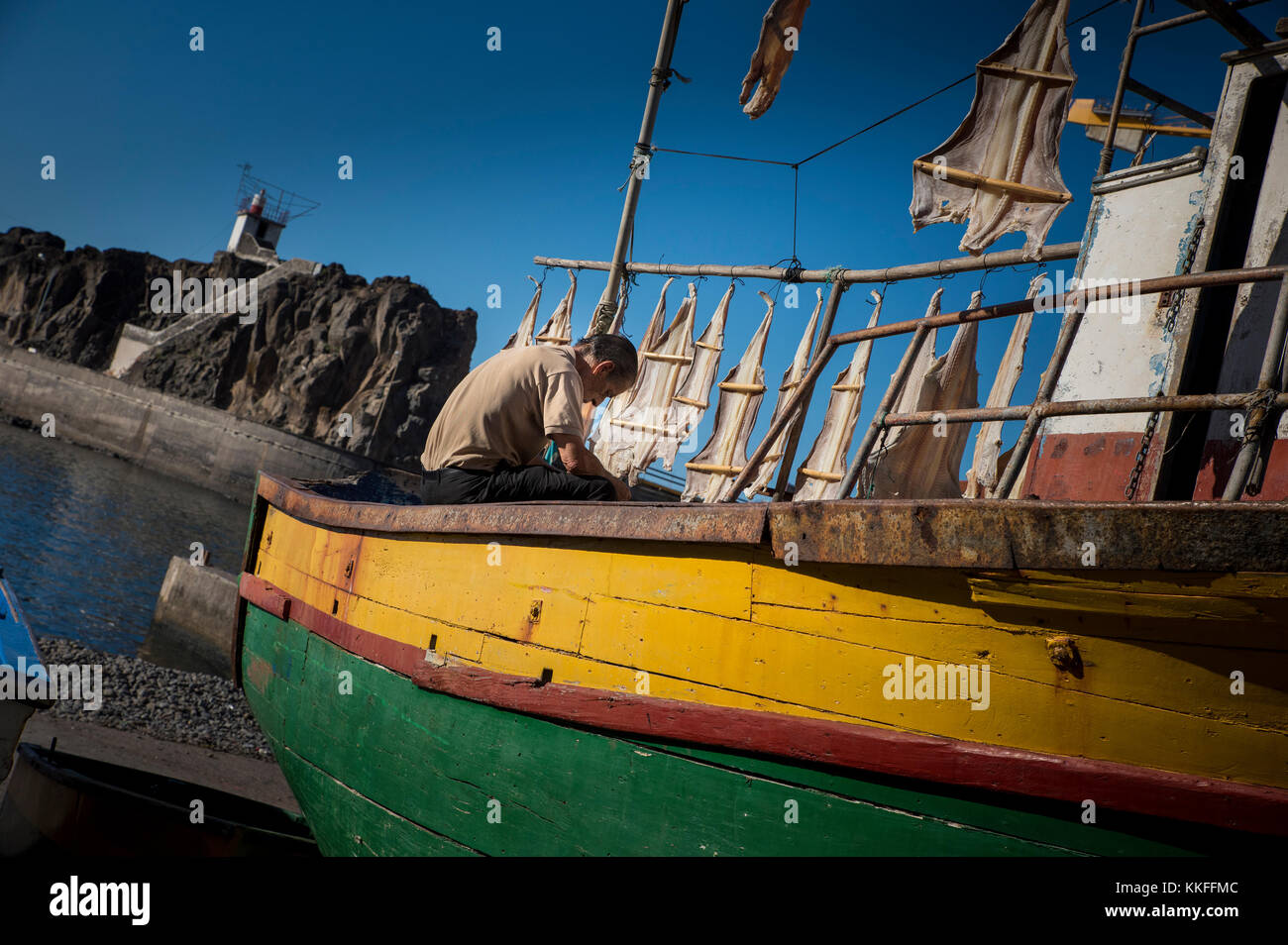 Fisherman drying fish on his boat Stock Photo - Alamy