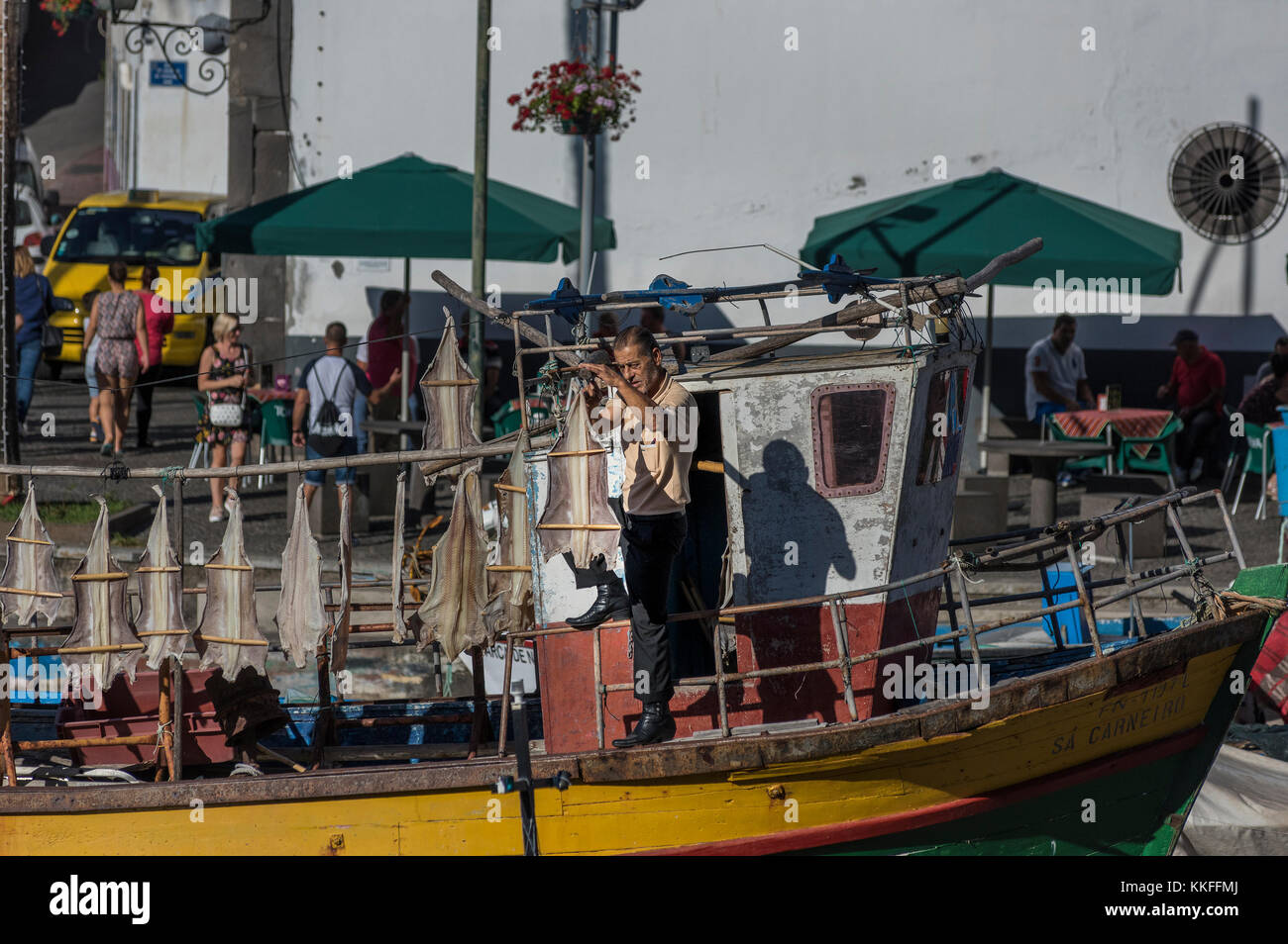 Fisherman drying fish on board his boat Stock Photo - Alamy