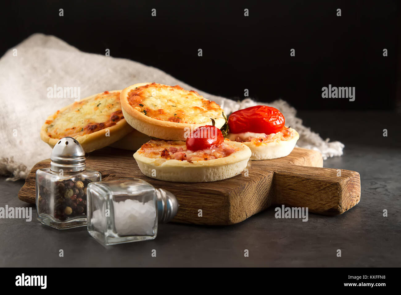 Italian homemade mini pizza with cheese, tomatoes. Dark background ...