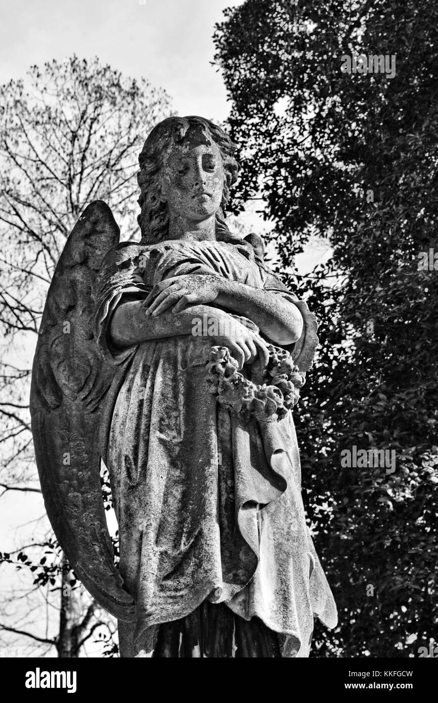 A pensive angel blows her head in sorrow over a grave in historic ...