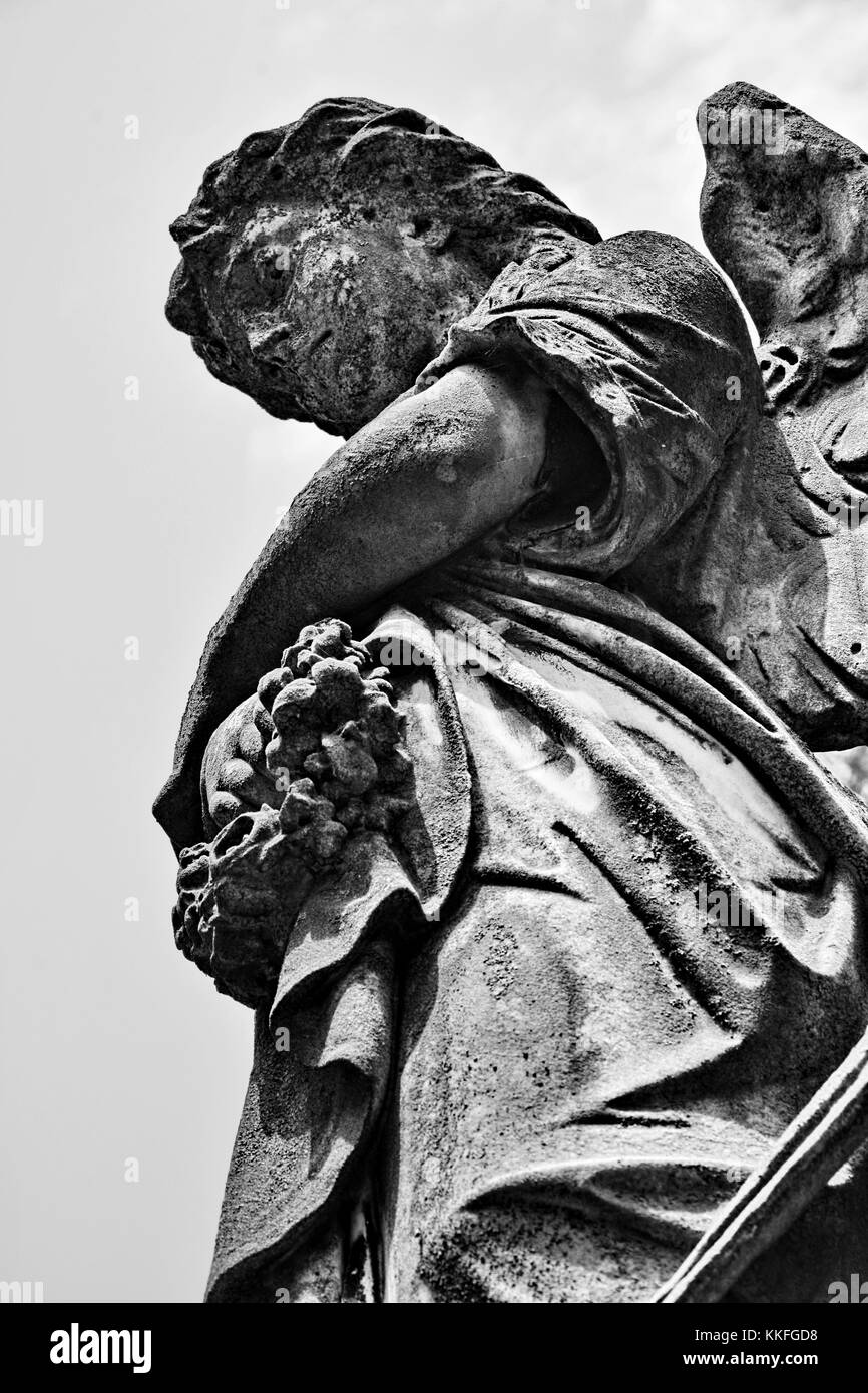 A pensive angel blows her head in sorrow over a grave in historic ...