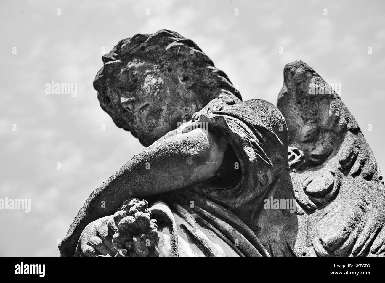 A pensive angel blows her head in sorrow over a grave in historic ...