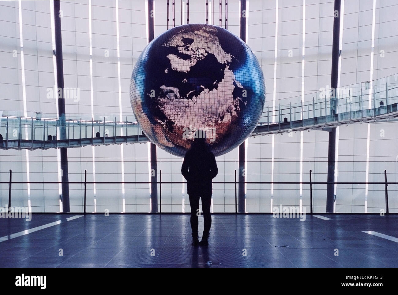 Silhouette of Woman looking at a large planet Earth, an exhibit at the ...