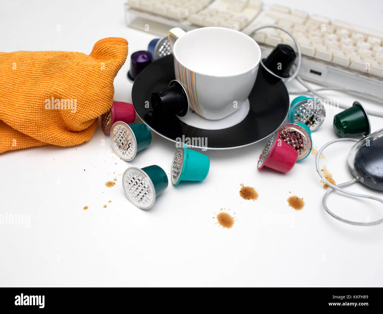 A messy office desk with spilled coffee and computer keyboard, indoor ...
