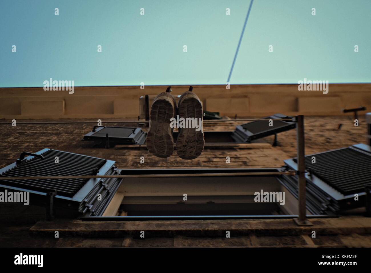 Pair of shoes hanging from the window Stock Photo - Alamy