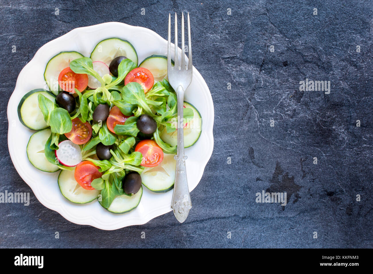 Fresh vegetarian salad in the plate on dark background,selective focus ...