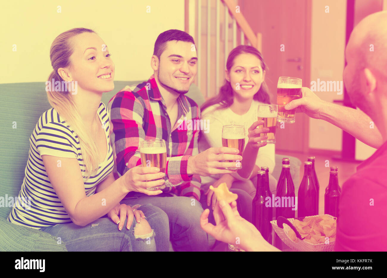 Happy smiling young adults drinking beer and laughing at home Stock ...