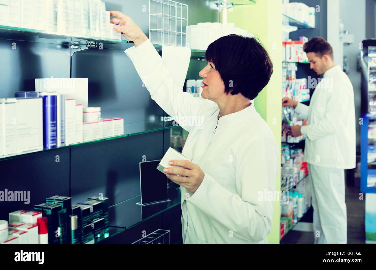 Portrait smiling pharmacist and pharmacy technician posing in drugstore ...