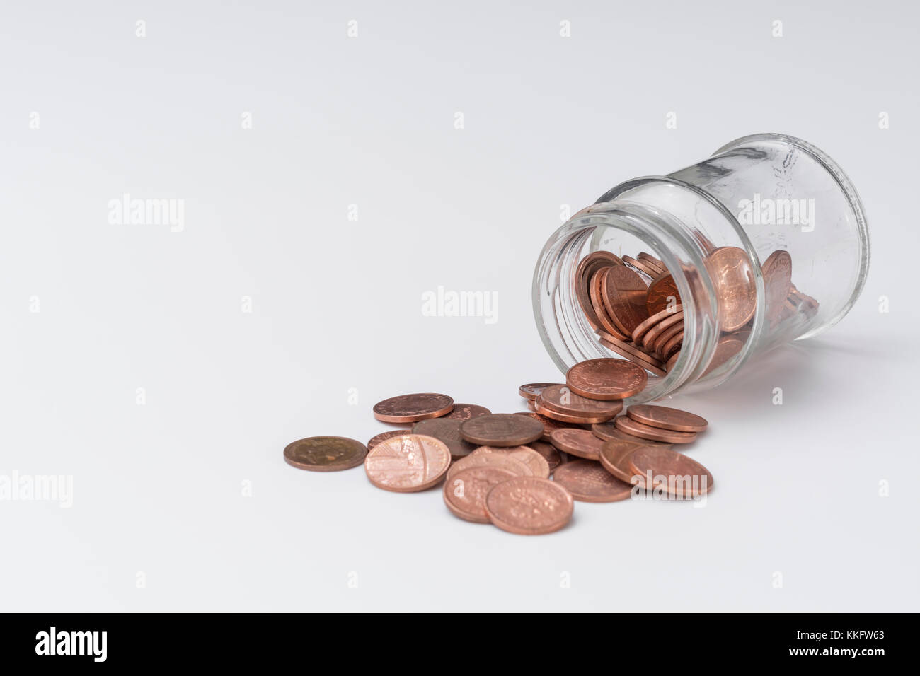 UK copper pennies cascading from glass jar. Saving pennies money ...