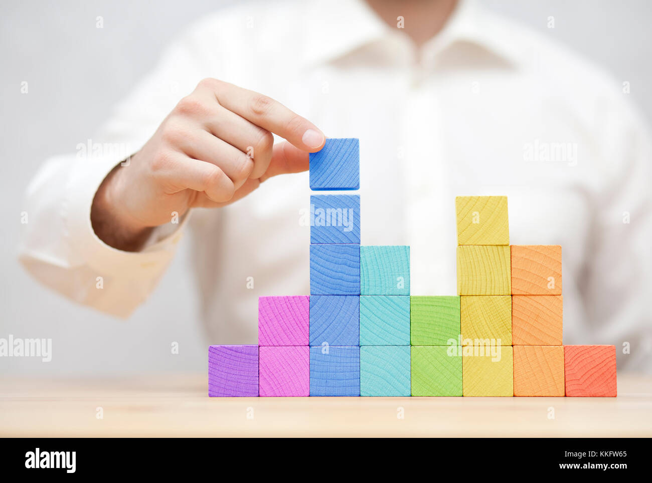 Man's hand stacking colorful wooden blocks. Business development ...