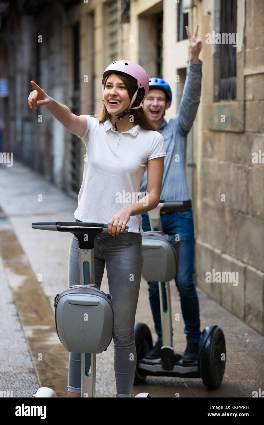 Happy young funny man and woman traveling through city by segways Stock ...