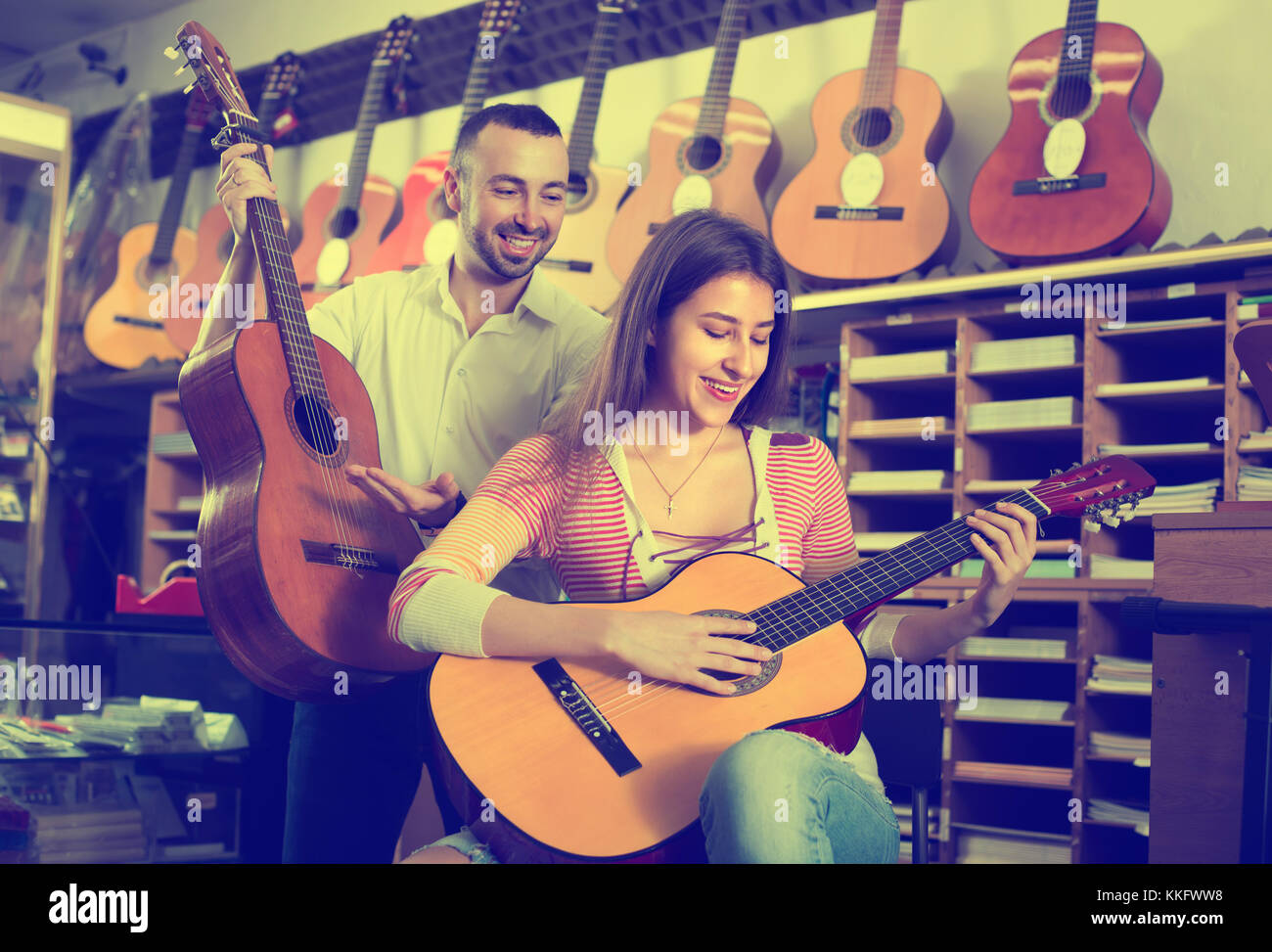 Joyful young musicians playing acoustic guitar in music instruments ...