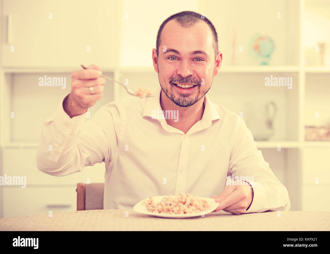 Positive young man ready to eat oat porridge in office Stock Photo - Alamy