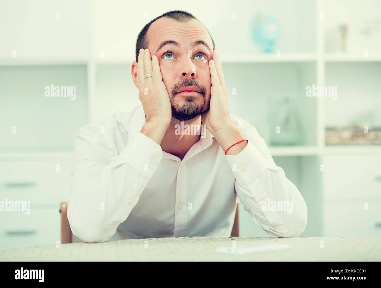 Disappointed worker at his office table feeling stressed, thinking and ...