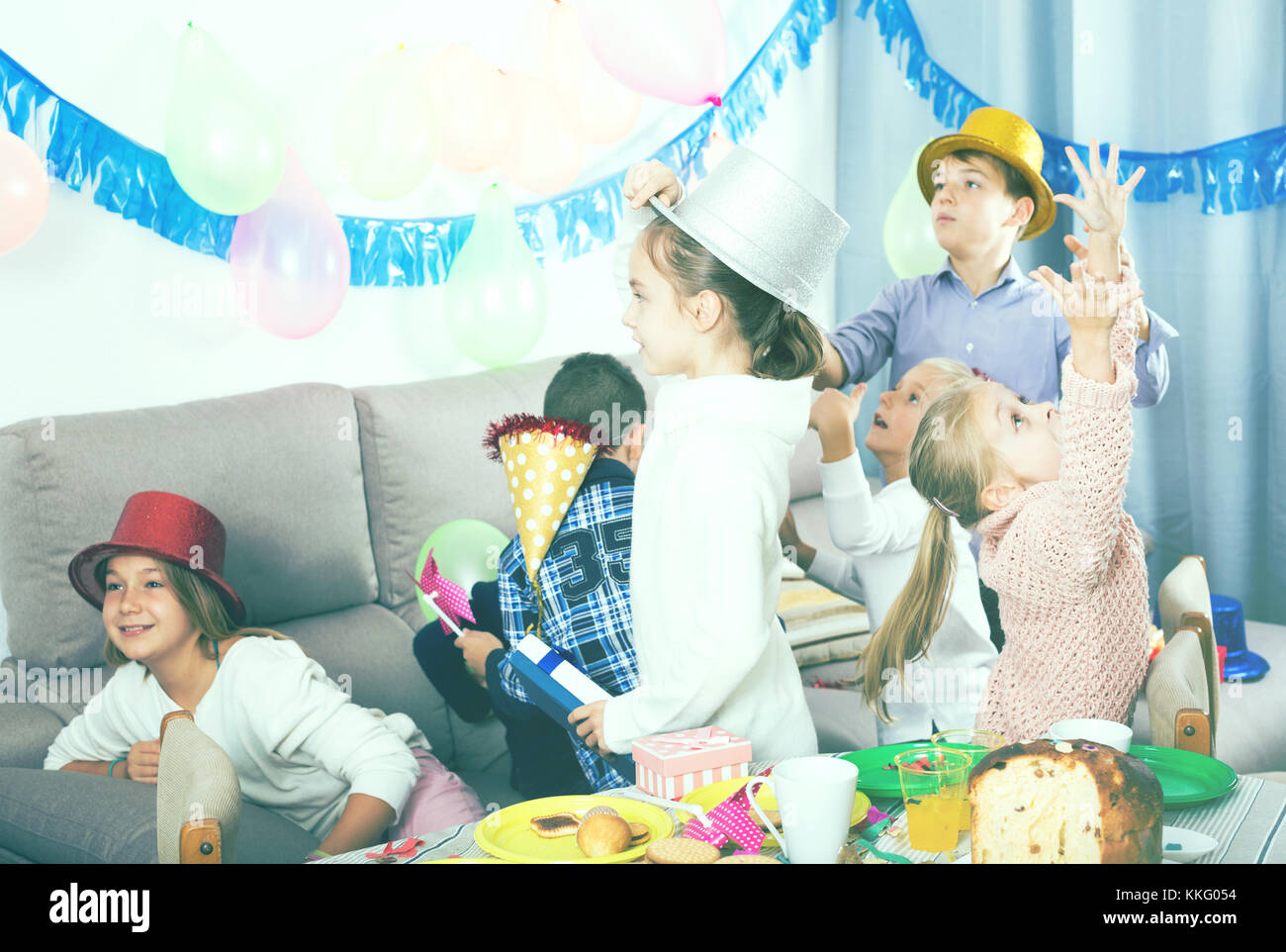 Cheerful children having fun during friend’s birthday party at his home ...
