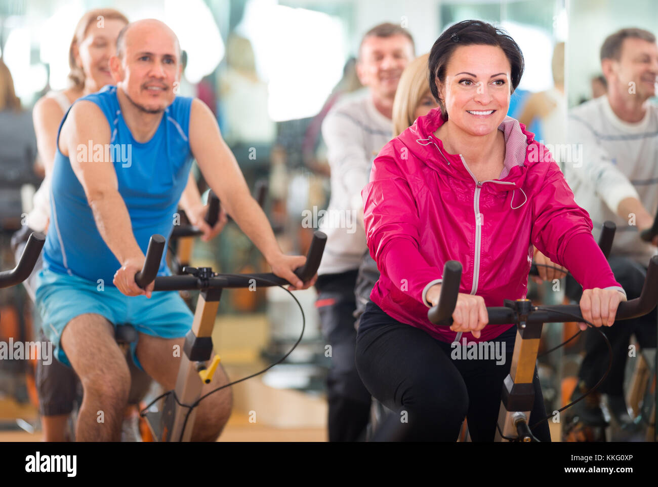 Woman cycling on fitness cycle with group of people Stock Photo - Alamy