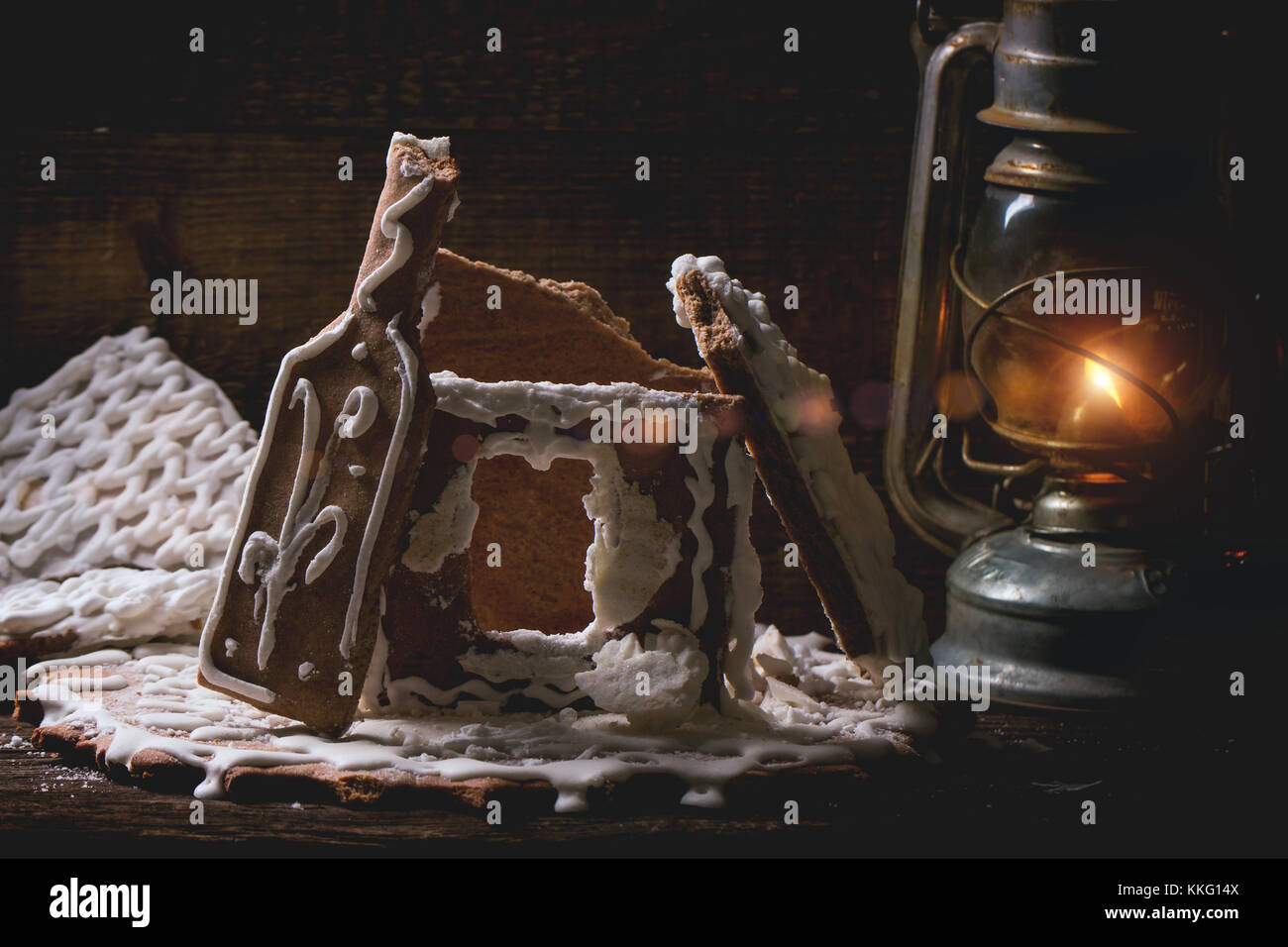 Broken gingerbread house with vintage lamp on wooden table Stock Photo ...