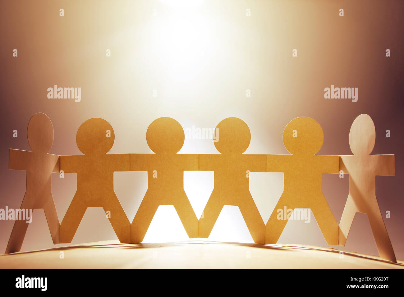 Team of paper chain people in a row holding hands Stock Photo - Alamy