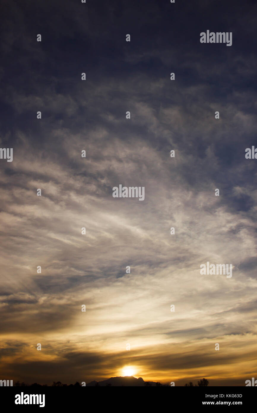 Vertical photo of a beautiful sunset sky over a volcano rich in clouds ...