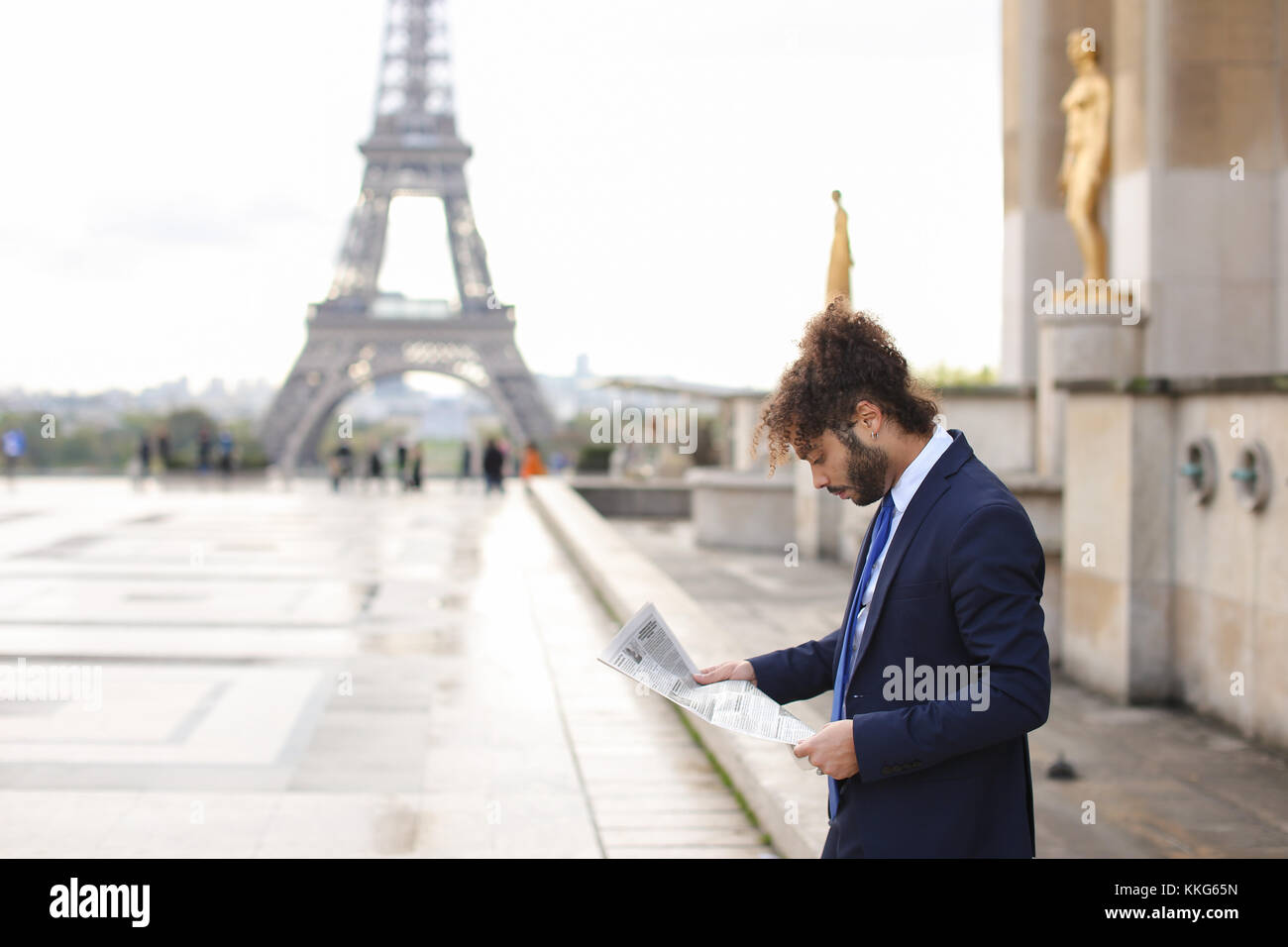 Hispanic journalist close to Eiffel Tower reading newspaper and Stock ...