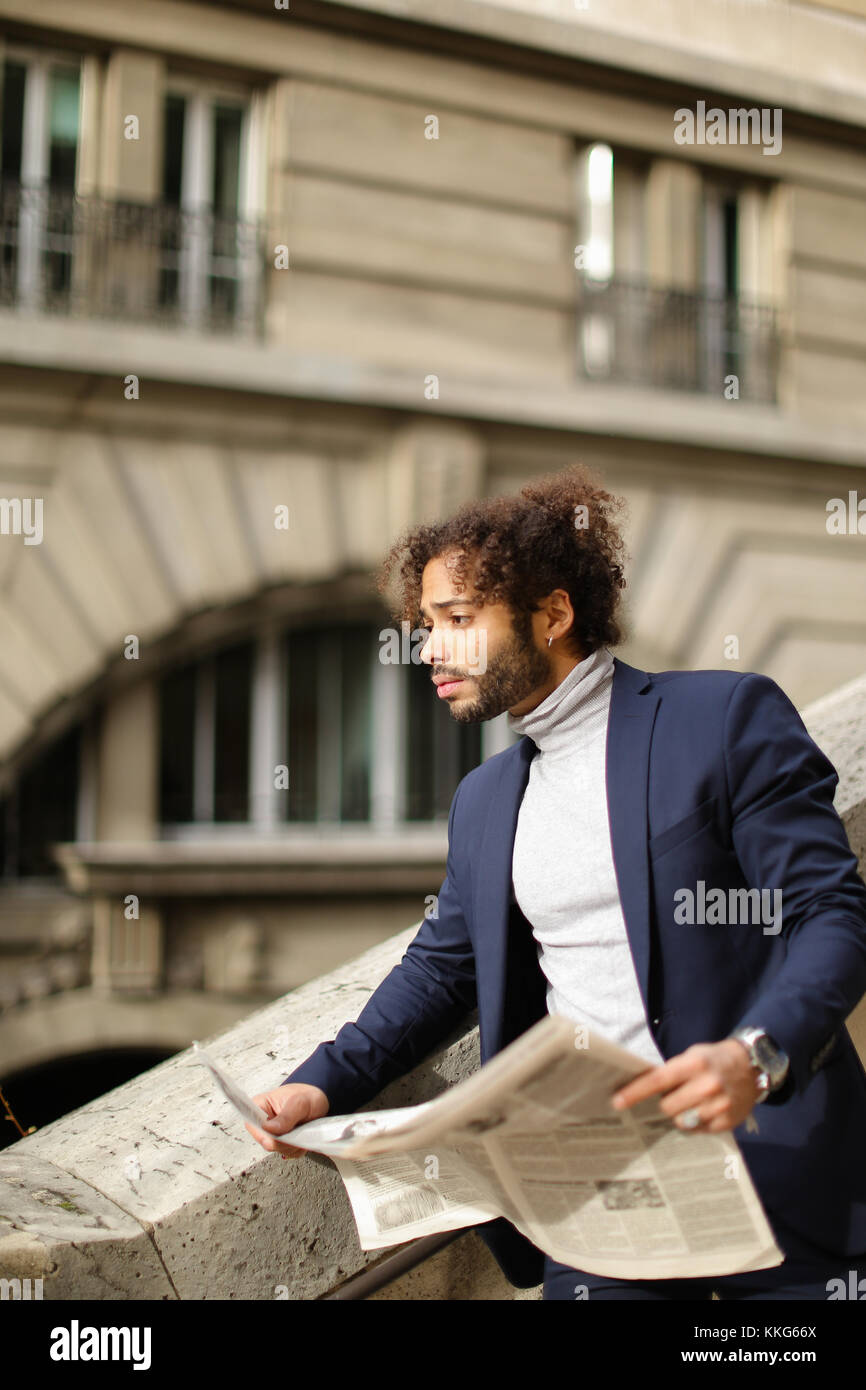 Upset guy reading newspaper outdoor Stock Photo - Alamy
