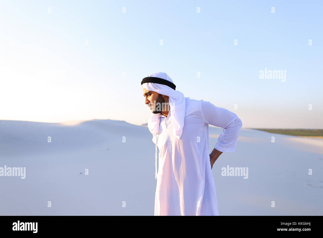 Handsome Arab sheik suffers from discomfort in back, standing in Stock ...
