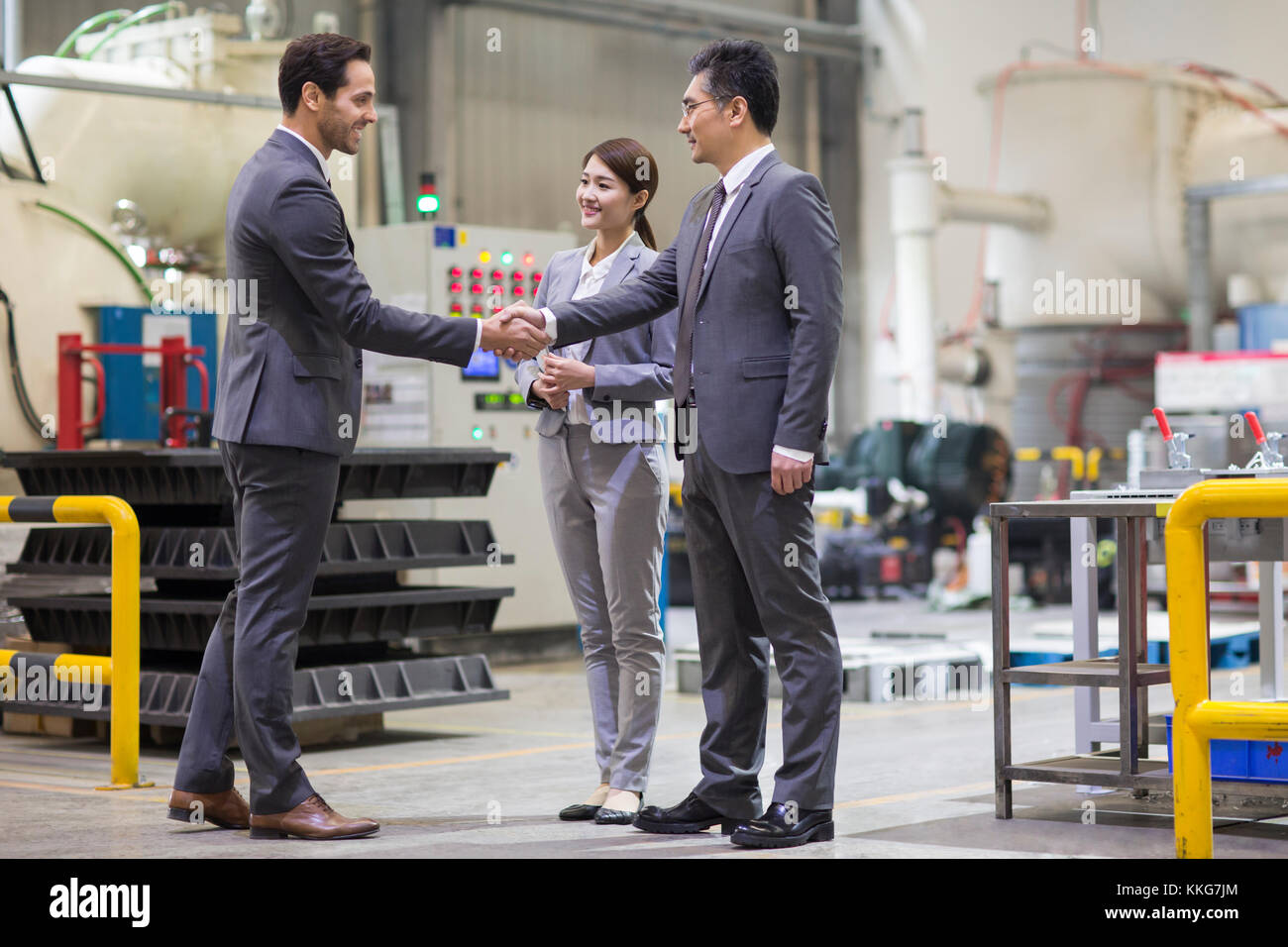 Business people shaking hands in the factory Stock Photo - Alamy