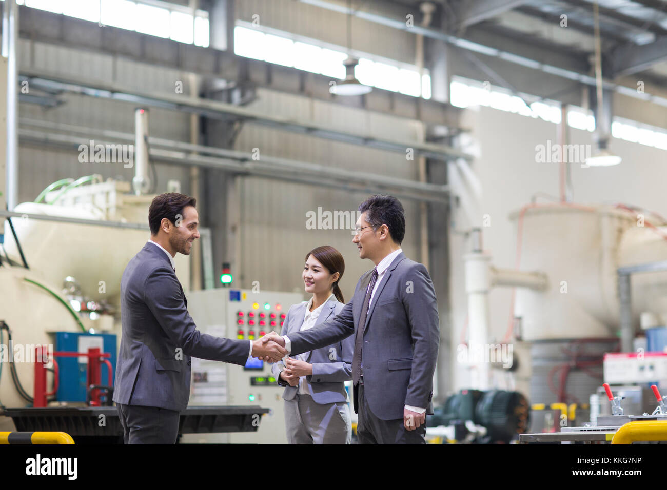 Business people shaking hands in the factory Stock Photo - Alamy