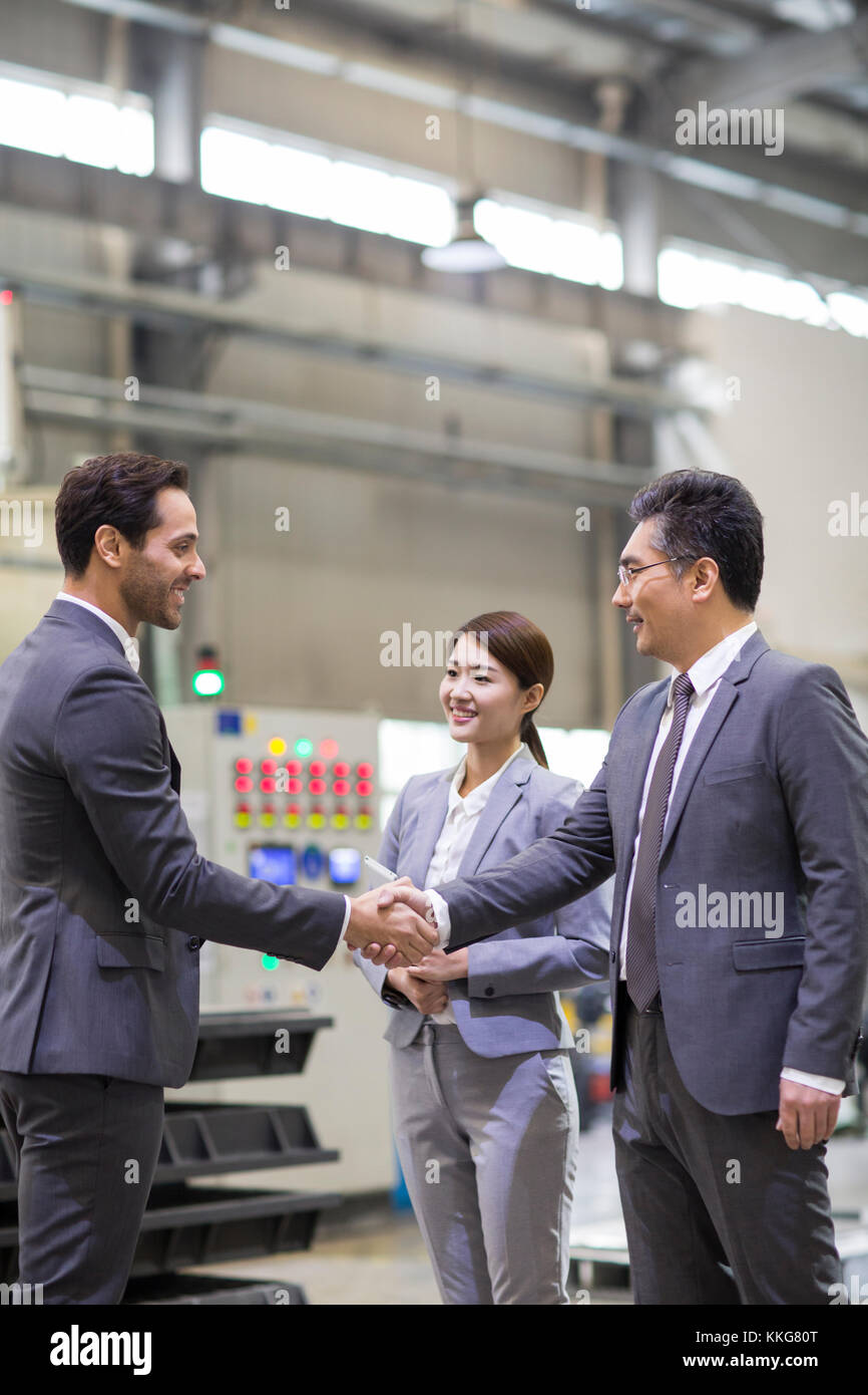 Business people shaking hands in the factory Stock Photo - Alamy