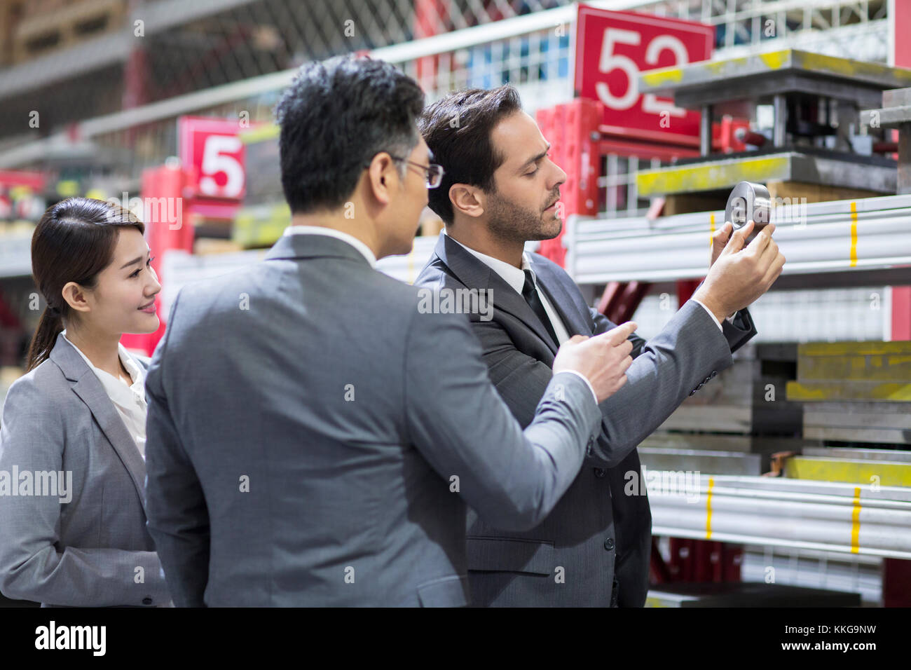 Business people checking machine parts in the factory Stock Photo - Alamy