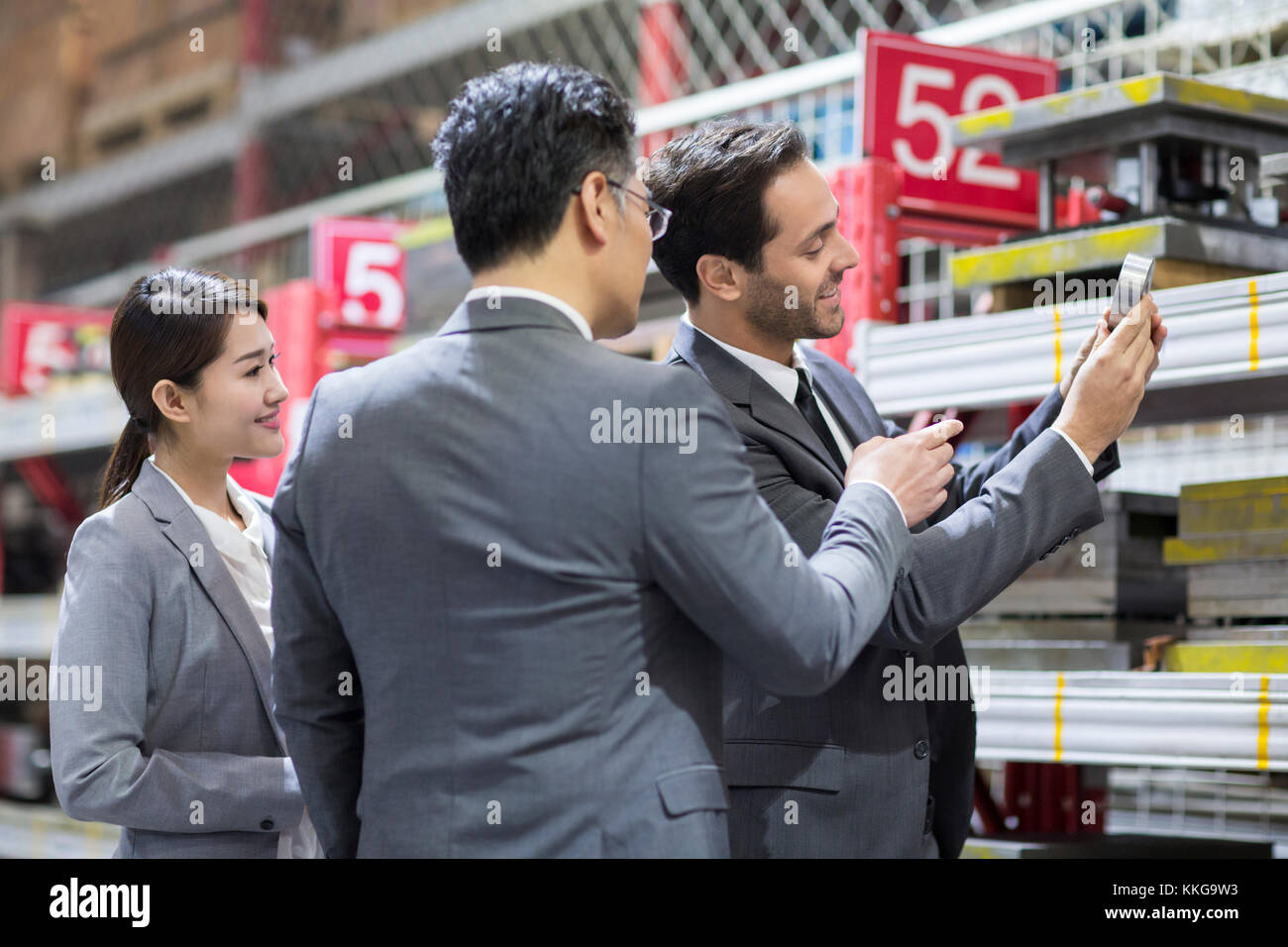 Business people checking machine parts in the factory Stock Photo - Alamy