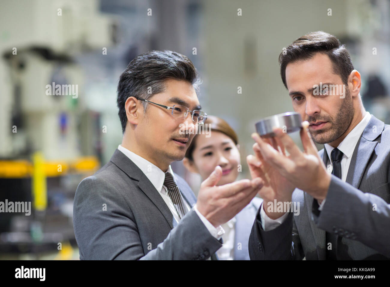 Business people checking machine parts in the factory Stock Photo - Alamy