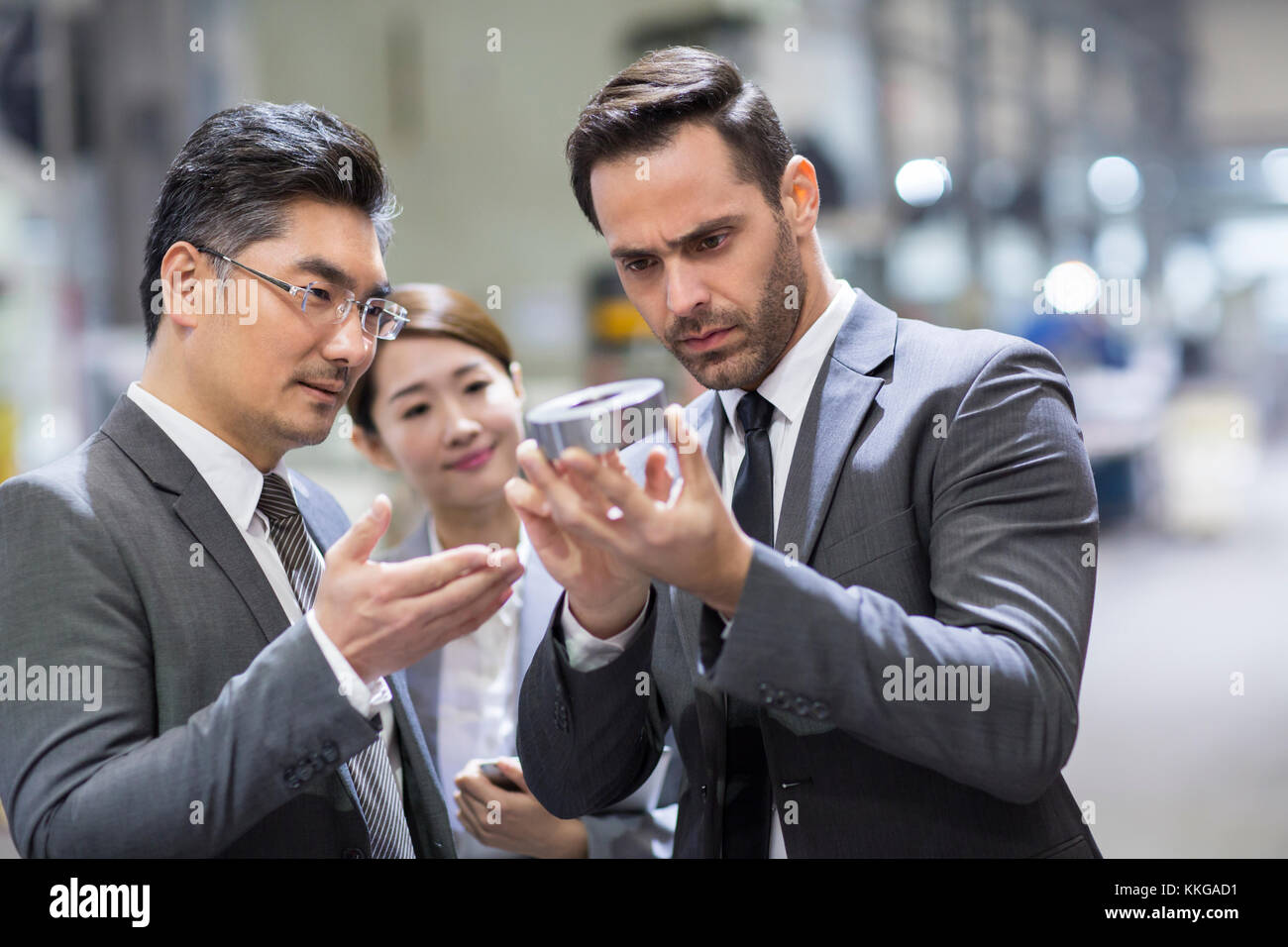 Business people checking machine parts in the factory Stock Photo - Alamy