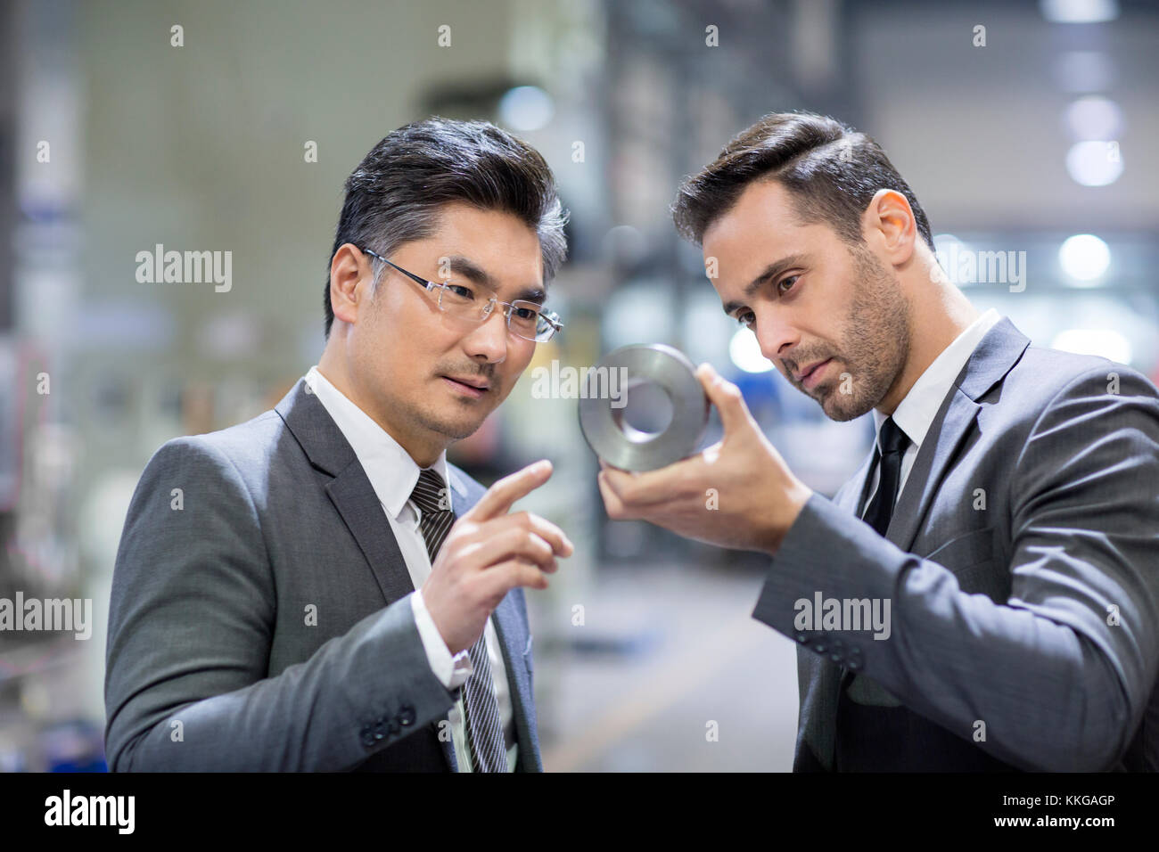 Business people checking machine parts in the factory Stock Photo - Alamy