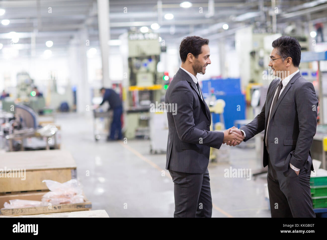 Business people shaking hands in the factory Stock Photo - Alamy