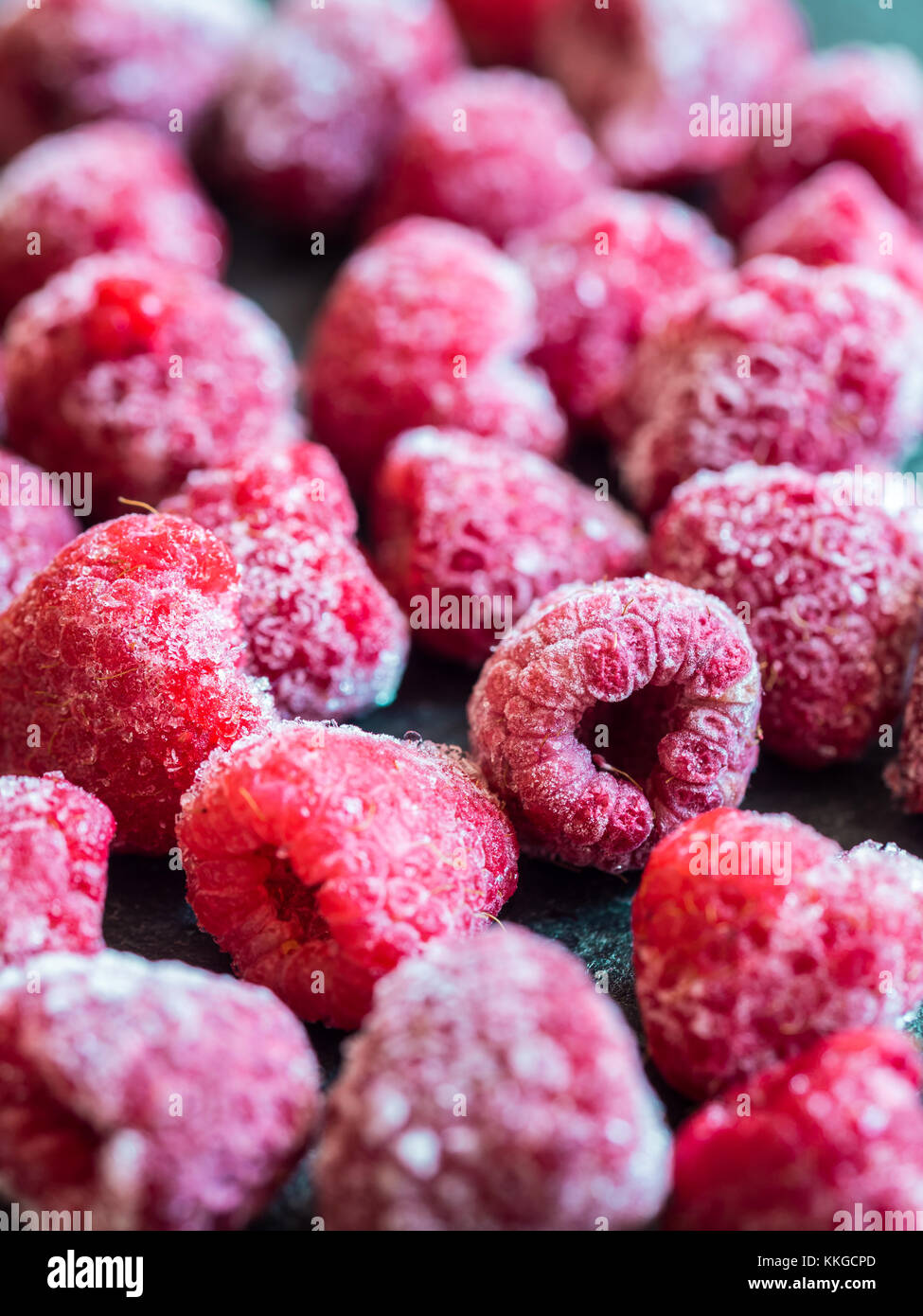Frozen raspberries on a dark surface, close up Stock Photo - Alamy