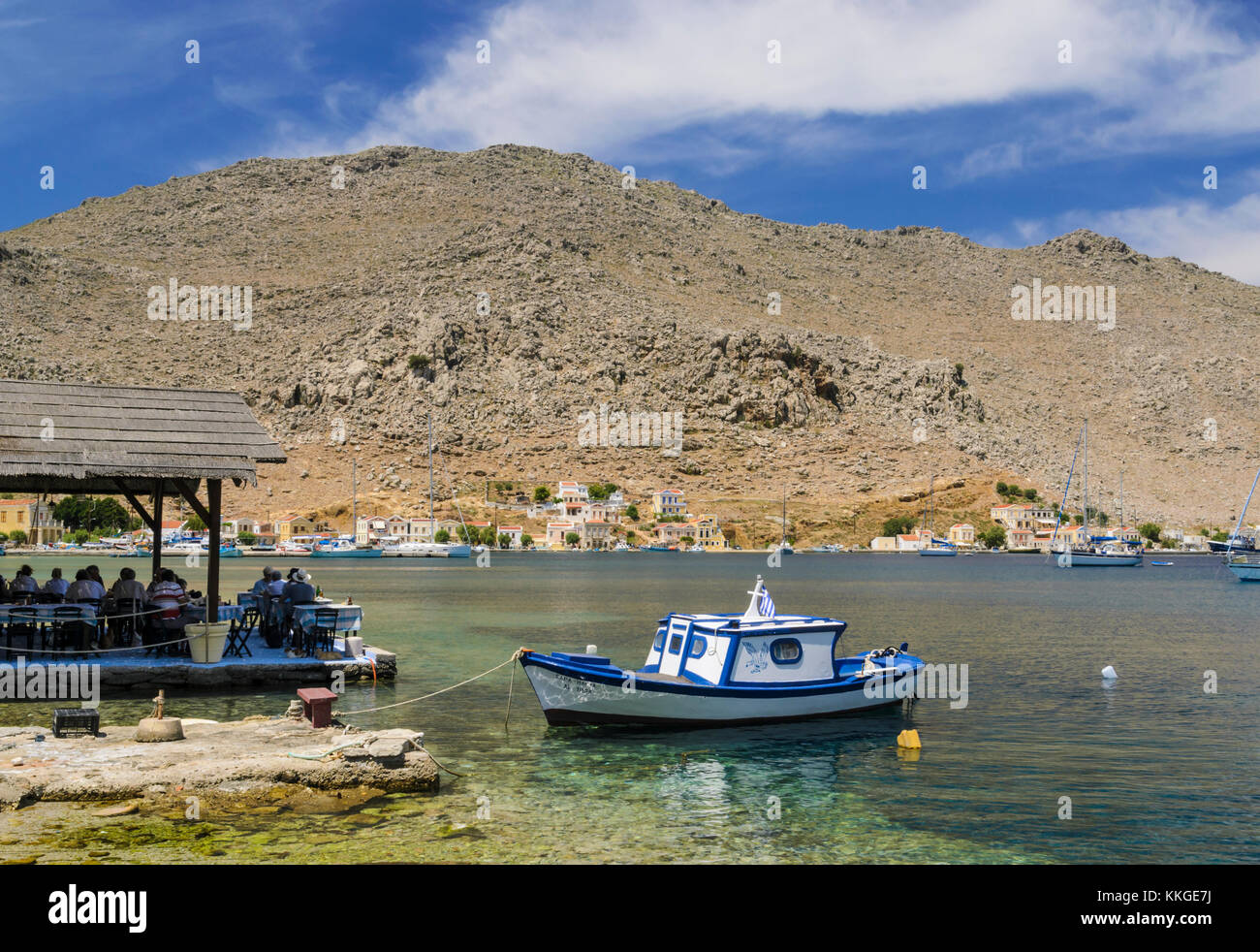 Waterfront taverna and fishing boat in Pedi Bay, Symi Island ...