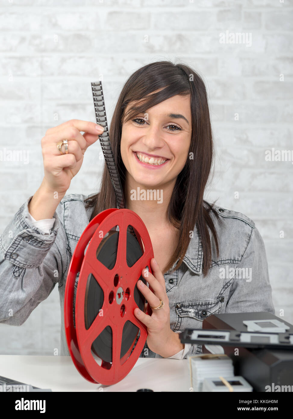 a pretty young woman looking at reel 16mm film Stock Photo - Alamy