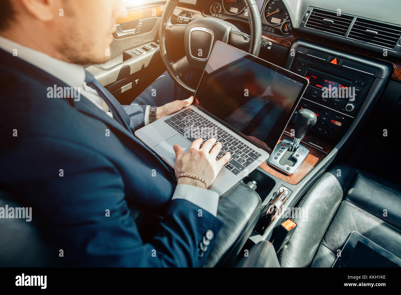 Serious businessman in a car with laptop Stock Photo - Alamy