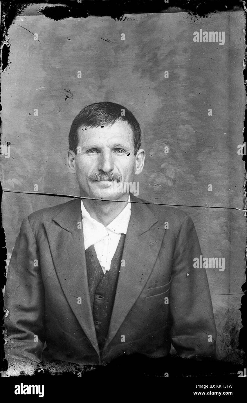This image depicts a man with a mustache wearing a suit, vest, and ...