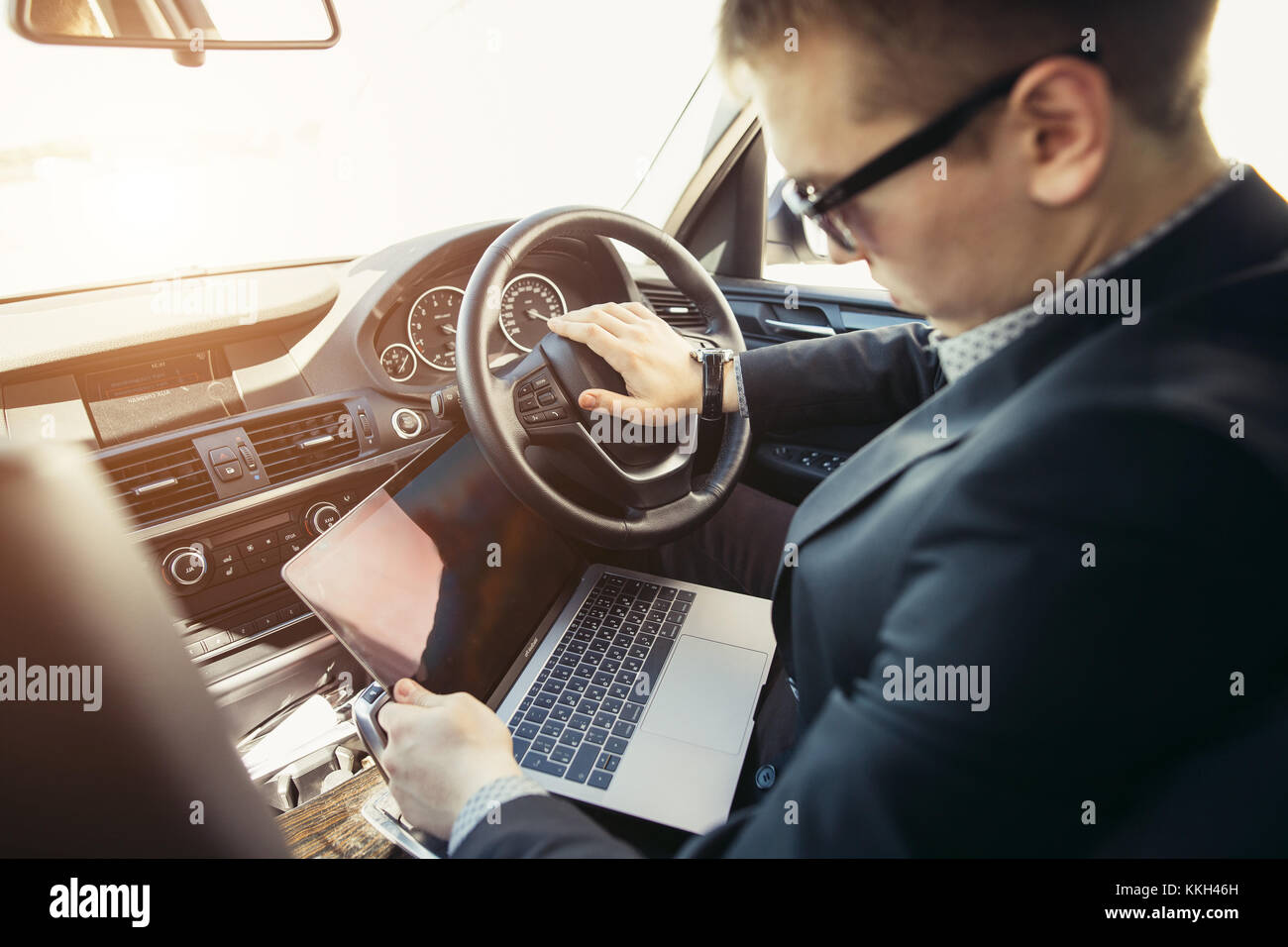 Serious businessman in a car with laptop Stock Photo - Alamy