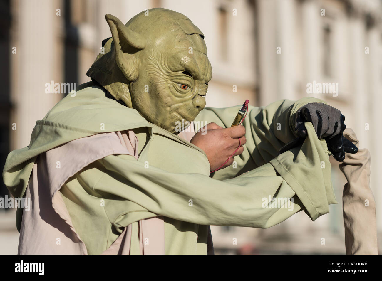 London, UK. 1st Dec, 2017. A floating Yoda street performer checks his ...