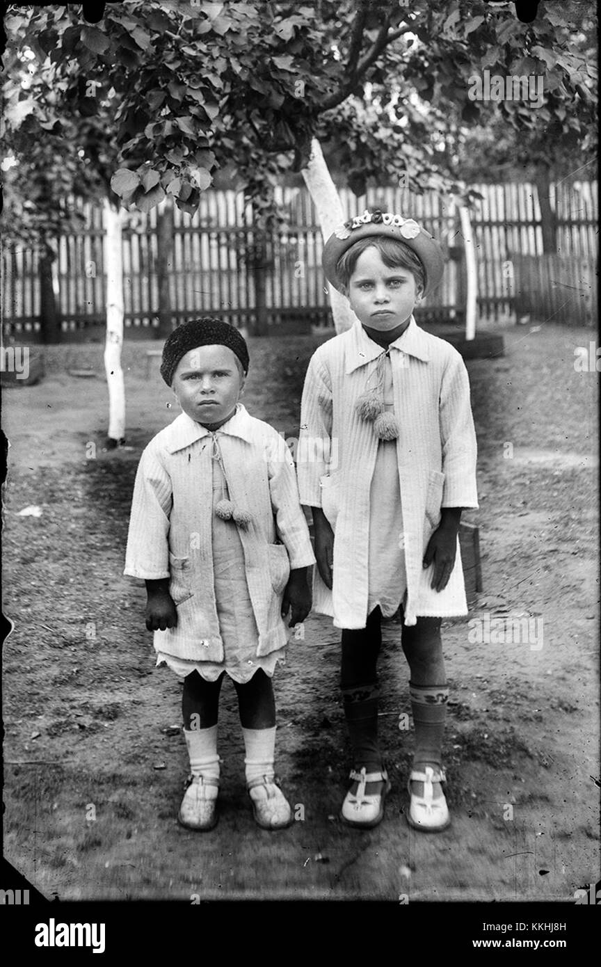 This image features two children playing outdoors in a natural setting ...