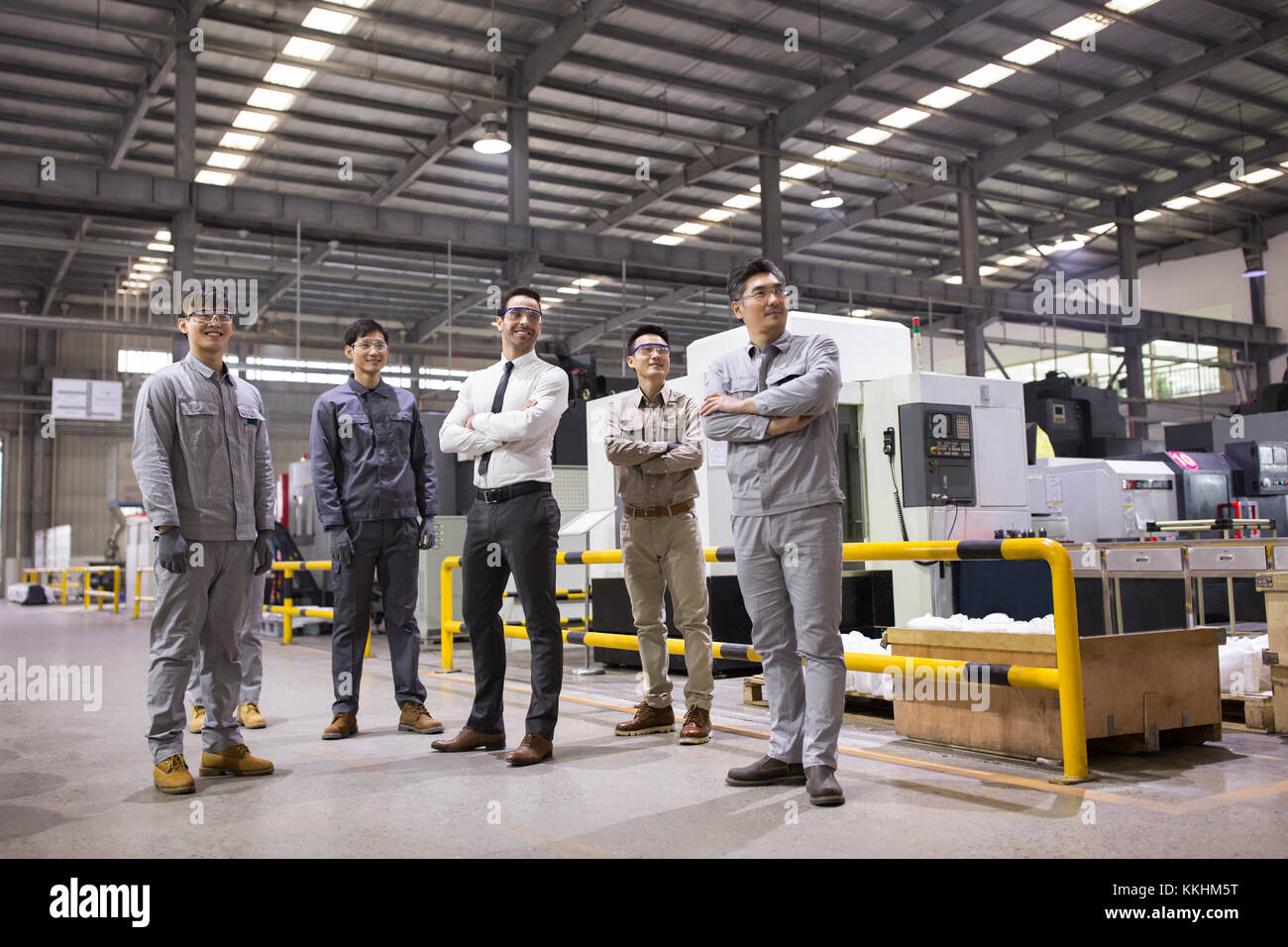 Confident businessman and engineering team in the factory Stock Photo ...