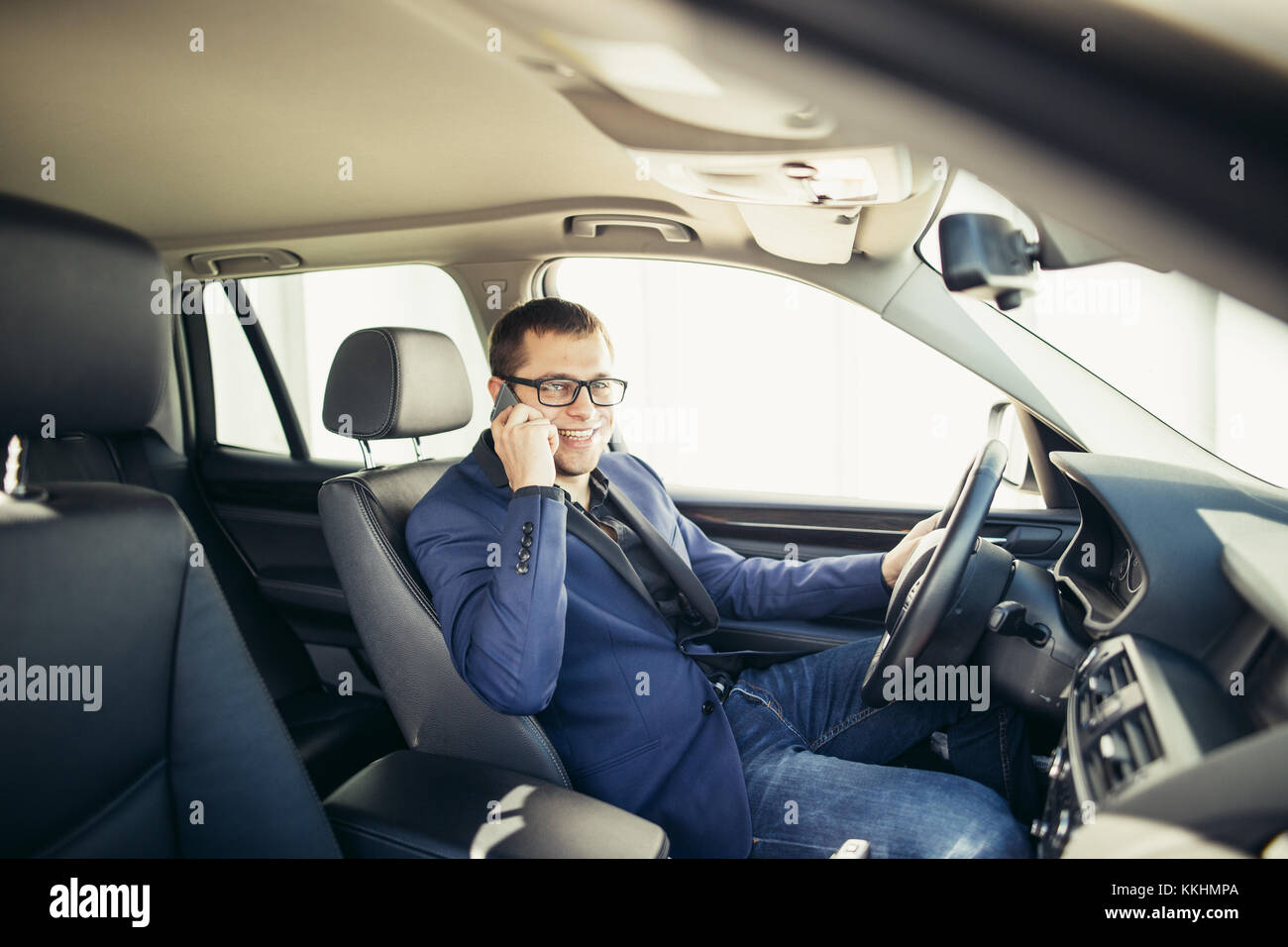 Man in the car reading and phoning Stock Photo - Alamy
