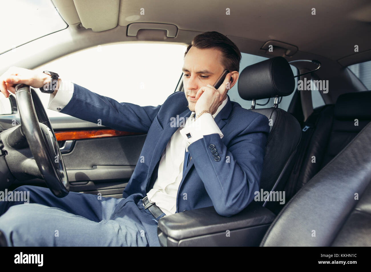 Man in the car reading and phoning Stock Photo - Alamy