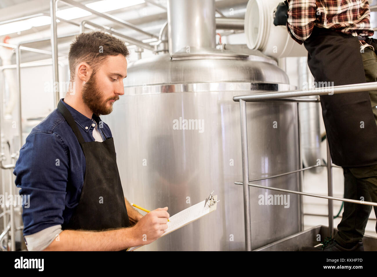 men working at craft brewery or beer plant Stock Photo - Alamy