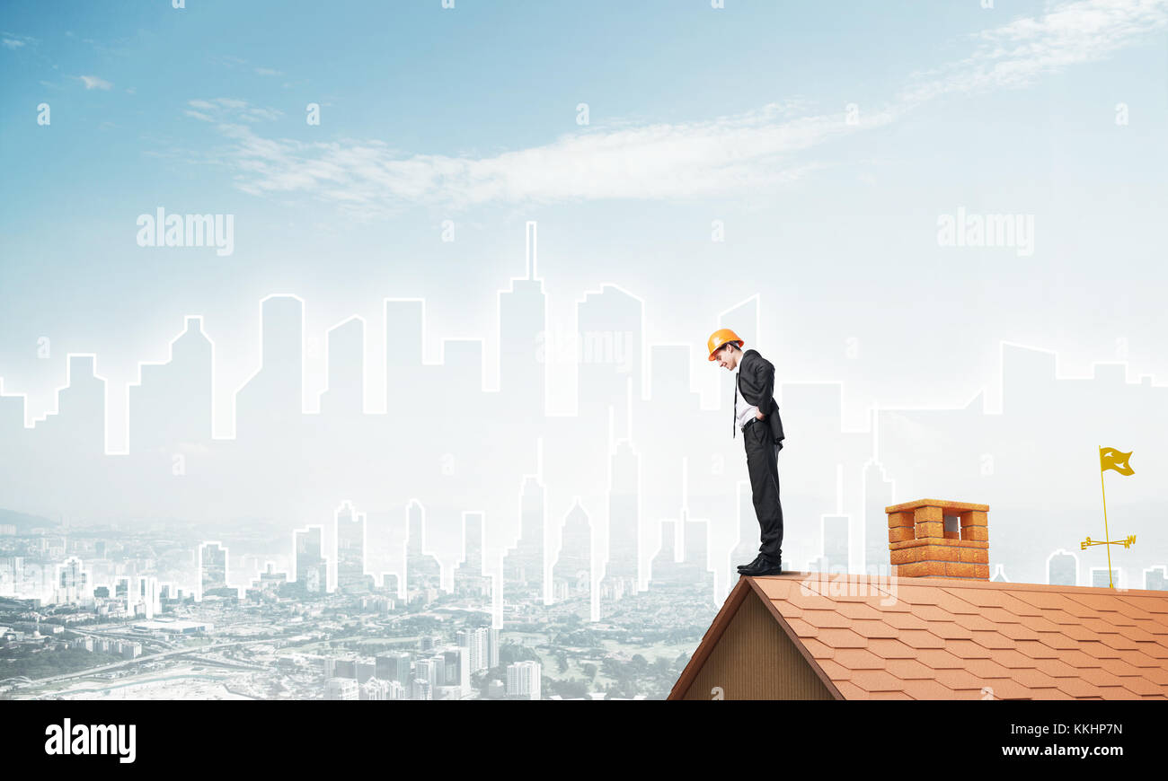Engineer man standing on roof and looking down. Mixed media Stock Photo ...
